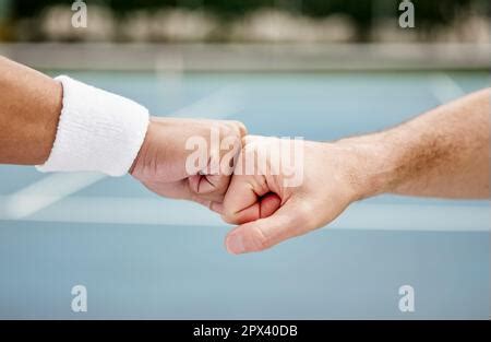 Geh und hol sie Zwei nicht wiedererkennbare Tennisspieler stoßen mit der Faust während sie