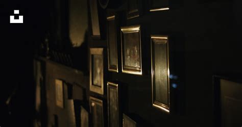 벽에 액자 그림이 잔뜩 걸려 있는 어두운 방 사진 Unsplash의 무료 벽 이미지