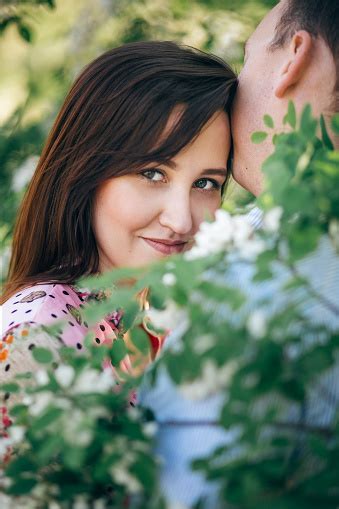 아름 다운 젊은 커플 부드럽게 포옹과 키스에 녹색 나뭇잎과 흰색 꽃 봄 정원에서 햇빛에 피 아카시아 나무에서 수용 하는 행복 한 가족 낭만주의 순간 2명에 대한 스톡 사진