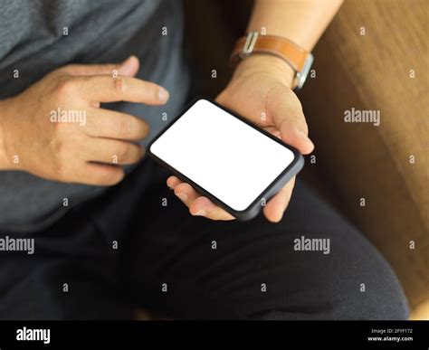 Top View Of Male Hands Using Smartphone Include Clipping Path Screen While Sitting On The Couch