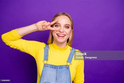 보라색 보라색 배경 위에 고립 된 미소 노란색 터틀넥 바지를 입고 V 표지판을 만드는 예쁜 소녀의 사진을 클로즈업 가을에 대한 스톡 사진 및 기타 이미지 Istock