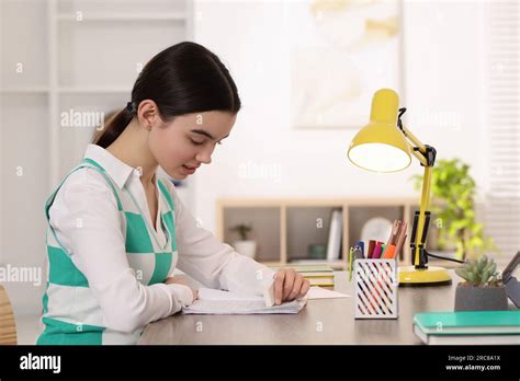 Teenage Girl Erasing Mistake In Her Notebook At Wooden Desk Indoors Stock Photo Alamy