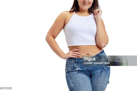 흰색 스튜디오 배경에서 고립된 포즈를 취하는 흰색 티셔츠와 청바지를 입은 플러스 사이즈 여성의 자른 이미지 25 29세에 대한 스톡 사진 및 기타 이미지 Istock