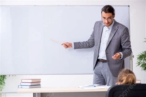 The Teacher With Young Girl In The Classroom Teacher With Young Girl In
