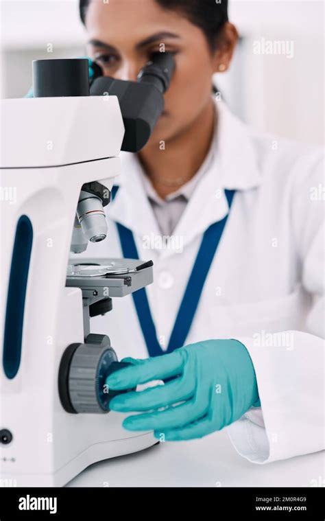 The Eye Of Every Scientist An Attractive Young Female Scientist Looking Through A Microscope