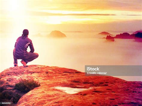 관광 사암 바위와 화려한 안개와 안개 아침 계곡에서에 보고의 피크에 앉아 슬픈 남자입니다 남자가 앉아 청바지에 남자입니다 가 산 안개 사암에 대한 스톡 사진 및 기타 이미지