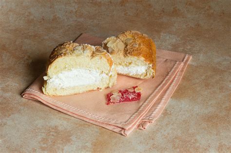 질감이 있는 추상적으로 디자인된 테이블에 크림과 아몬드로 채워진 전통적인 케이크 장식과 함께 우아한 냅킨에 설탕을 입힌 설탕에 절인 과일 조각 0명에 대한 스톡 사진 및