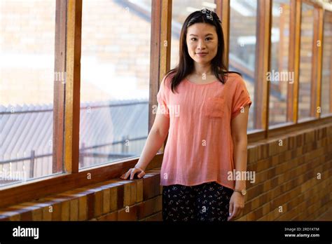 Portrait Of Happy Asian Female Teacher In Elementary School Corridor