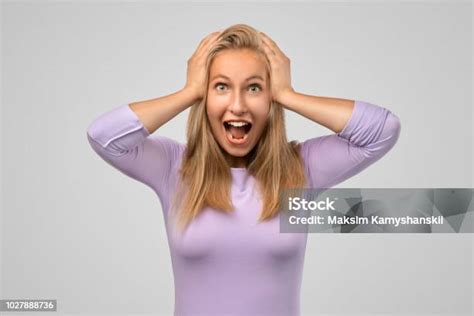 와우 가까이 세로 젊은 여자 보고 흥분 그녀의 입 열 머리에 손을 들고 긴 머리를 가진 아름 다운 소녀 회색 벽을 격리 놀란 충격 기 절 긍정적인 인간의 감정 겁먹은에 대한