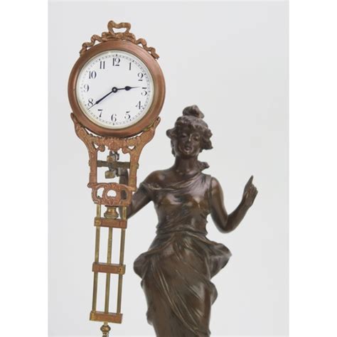 A Bronzed Metal Mystery Timepiece Modelled As A Young Lady Standing In