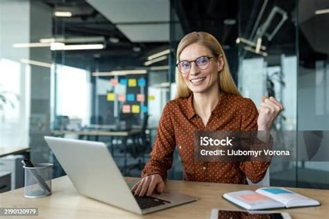자신감 넘치는 비즈니스 우먼이 현대적인 사무실 공간에서 노트북으로 작업하면서 성공을 축하하며 동기 부여와 성취를 보여줍니다 경영자에 대한 스톡 사진 및 기타 이미지 Istock