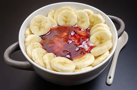 바나나를 곁들인 오트밀 회색 흰색 그릇에 검은 색 배경에 흰 숟가락을 넣은 잼 건강한 아침 식사 0명에 대한 스톡 사진 및 기타 이미지 Istock