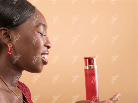 Gros Plan D Une Femme Africaine Ayant Un Parfum En Main Sur Un Fond