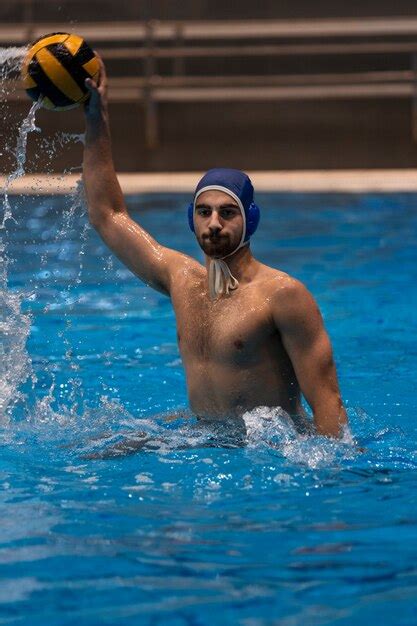 Atleta Masculino Jogando Pólo Aquático Na Piscina Coberta Foto Grátis