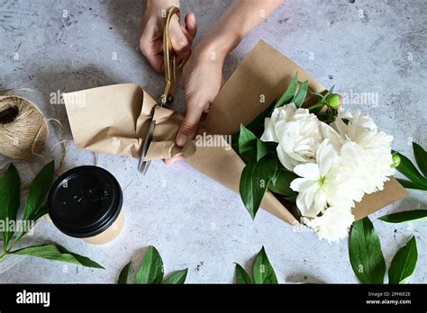 Florist Makes A Bouqueta Woman Makes A Bouquet Of Peonies A Bouquet Of Kraft Paper Pruning