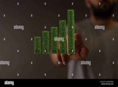 a businessman pointing to a 3d render of a green rising histogram with
