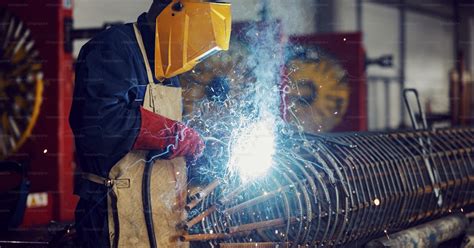 중공업 금속 작업자가 공장에서 용접기로 금속 프레임워크를 용접하고 있습니다 사진 Unsplash의 용접공 이미지
