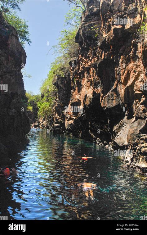 People Snorkeling In Las Grietas An Ocean Water Pool Positioned Between Two Tall Cliffs Puerto