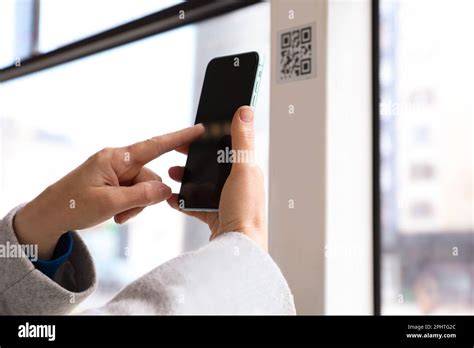 Woman Scanning QR Code With Her Smartphone In Public Transport Closeup Stock Photo Alamy