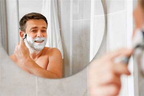 한 남자가 안전 면도기로 얼굴을 면도하고 둥근 거울을 본다 거울에 대한 스톡 사진 및 기타 이미지 거울 면도 개념 Istock