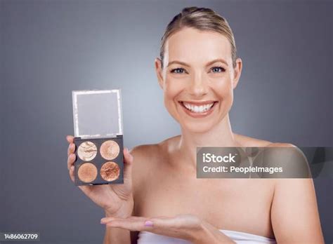 메이크업 팔레트 초상화와 화장품 파운데이션 아이 파우더를 스튜디오 배경에 두고 있는 여성 미소 화장품 관리 및 미용 아이섀도