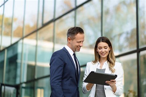 야외에서 태블릿 컴퓨터에서 작업을 논의하는 두 명의 비즈니스 사람 건물 외관에 대한 스톡 사진 및 기타 이미지 건물 외관 기업 문화 기업 비즈니스 Istock
