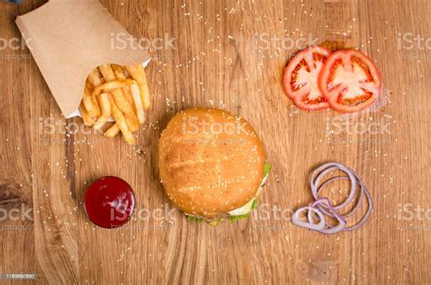 감자 튀김과 나무 테이블에 큰 맛있는 치즈 버거 치즈 토마토 샐러드와 함께 맛있는 점심 식사 맥주와 패스트 푸드 0명에 대한