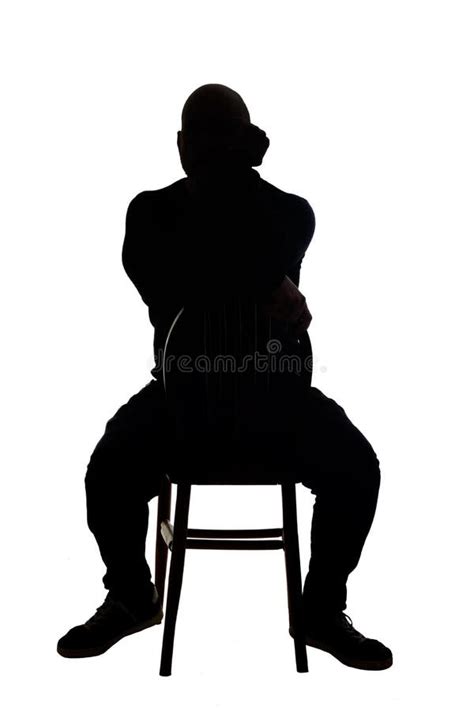 View Of The Silhouette Of A Man Sitting On Chair With Casual Clothes