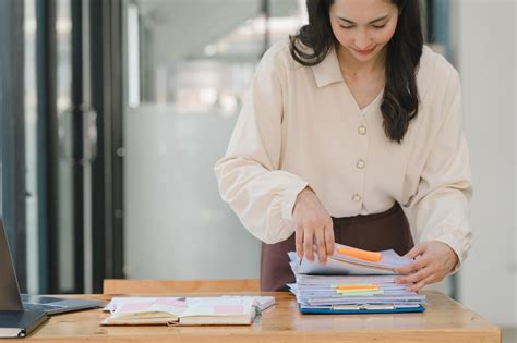 Premium Photo A Businesswoman Is Sifting Through Stacks Of Paper