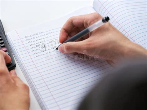 A Student Doing Math In A Notebook Using A Scientific Calculator Stock