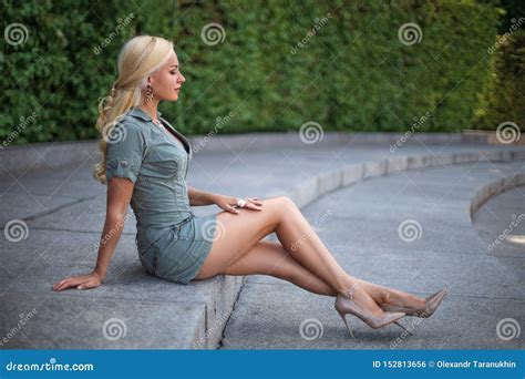 Mädchen Mit Den Perfekten Beinen Die Am Stadtplatz Sitzen Stockfoto