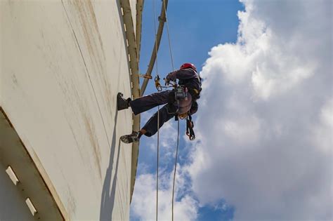 남성 작업자 로프 접근 높이 안전 점검 두께 저장 오일 및 가스 탱크 프리미엄 사진
