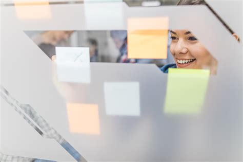 크리에이 티브 여 자가 사무실에 접착 메모에 비즈니스 전략을 쓰고 웃 고 계획에 대한 스톡 사진 및 기타 이미지 계획