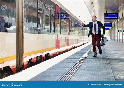 Portrait Of Business People Running To Catch The Train In Station Stock