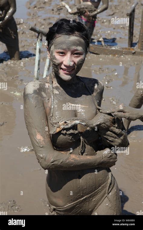 A Young Chinese Model Who Gets Muddy All Over Poses In The Mud On A Tidal Flat On The Xiushan