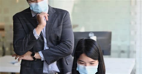 보호 마스크를 쓴 사업가들은 현대 사무실에서 노트북으로 진행 상황을 나타내는 재무 수치를 분석합니다 사진 Unsplash의