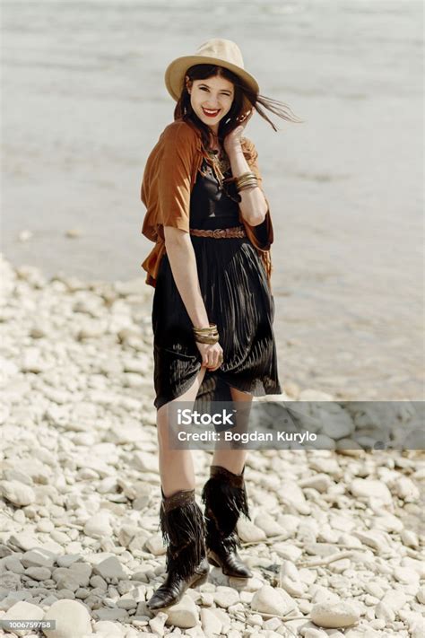 아름 다운 세련 된 Boho 여자 모자 프린지 판 쵸와 부츠와 함께 웃 고 여자 집시 히피에 젊은 여행자 강 바위 산에 가까운 포즈 봐 관능적인 보세요입니다 대기 순간입니다