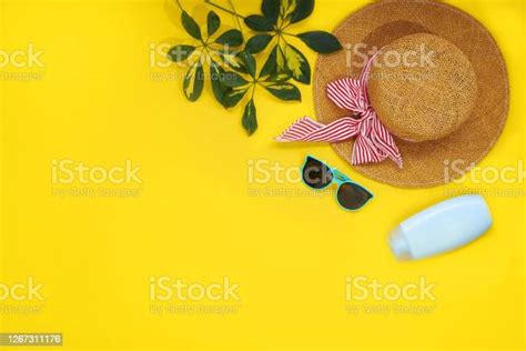 해변 시즌 액세서리 밀짚 모자 선글라스 자외선 차단제 및 노란색 배경에 격리 된 쉐플래어를 남깁니다 상단 보기 플랫 레이 개념에