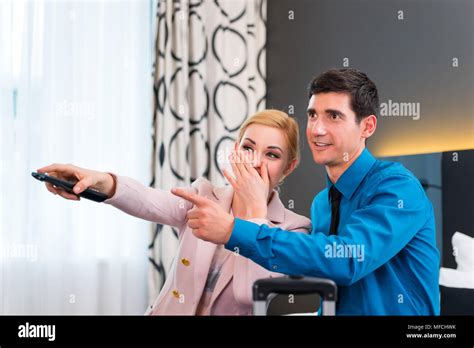 Couple Switching TV With Remote Control In Hotel Room Stock Photo Alamy