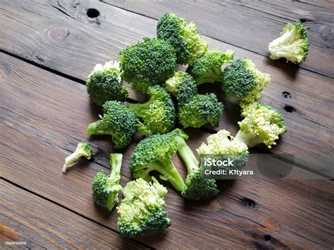 Pieces Of Brocooli Are Lying On A Wooden Table In The Kitchen Stock