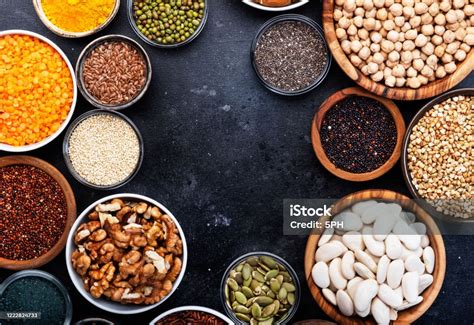 슈퍼푸드 콩류 견과류 씨앗 시리얼을 회색 배경의 그릇에 담습니다 치아 스피룰리나 콩 고지 베리 퀴노아 심황 녹두 메밀 렌즈콩 아마 씨 야생 쌀 및 아몬드와 같은 슈퍼 푸드