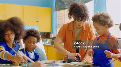 어린이 그룹 여성 및 교실에서 함께 그림을 그리고 색채 학교 및 도움을 통해 학습 또는 개발합니다 어린 학교 아이들 교육 창의성 및 아카데미 학생을 위한 교사 및 예술 손에