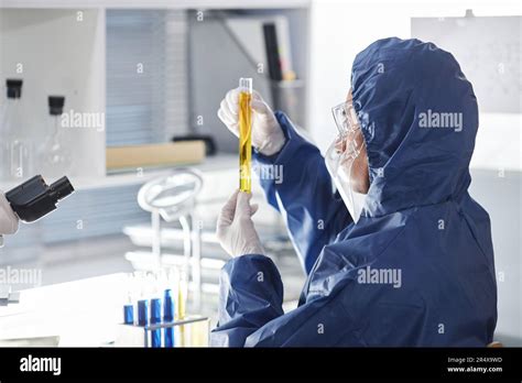 Side View Of Scientist Wearing Protective Suit Working With Hazardous Materials In Laboratory Side View Of Scientist Wearing Protective Suit Working With Hazardous Materials In Laboratory