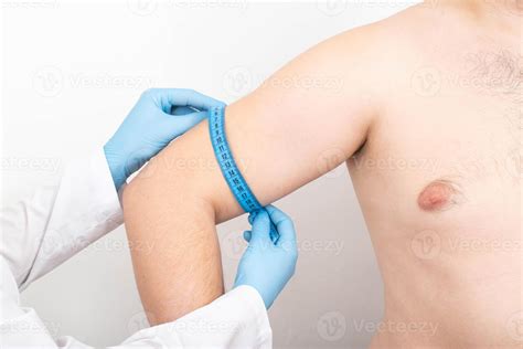 Doctor Measures A Mans Triceps With A Measuring Tape For Triceps Augmentation With Cosmetic