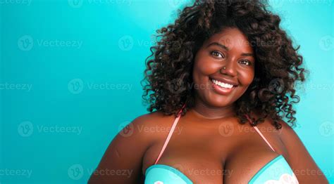 A Plus Size Black Afro American Bikini Model With Curly Hair Is Smiling