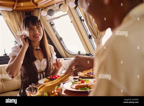 An Interracial Couple Enjoys A Romantic Lunch In A Camper Van Savoring A Delicious Meal