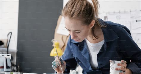 스튜디오의 어린 소녀 예술가는 그림을 그리고 아크릴 물감을 섞고 그림의 기초를 준비합니다 여성 화가 그리기 용 액세서리 새로운 회화 기법 캔버스 프레임 미술