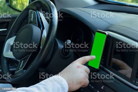 남성 손은 차 안에 빈 녹색 스크린이있는 스마트 폰을 사용합니다 Gps 네비게이터 응용 프로그램을 통해 위치 검색 통신 기술의
