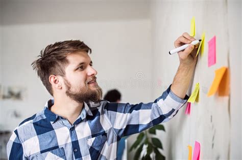 man writing ideas on colorful sticky notes colleagues working on a new project together in a