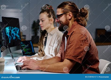 Side View Of Young Male It Engineer Typing On Laptop Keyboard Stock